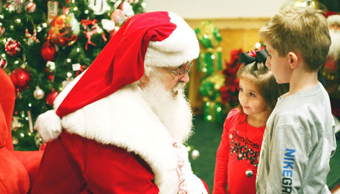 why do santa claus comes in red dress and give gifts to the childrenে